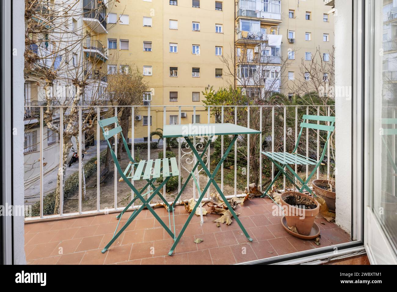 Small urban terrace of a residential home with a green folding metal ...