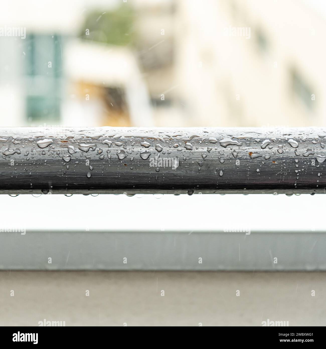 A round tube railing filled with water drops on a rainy day Stock Photo ...