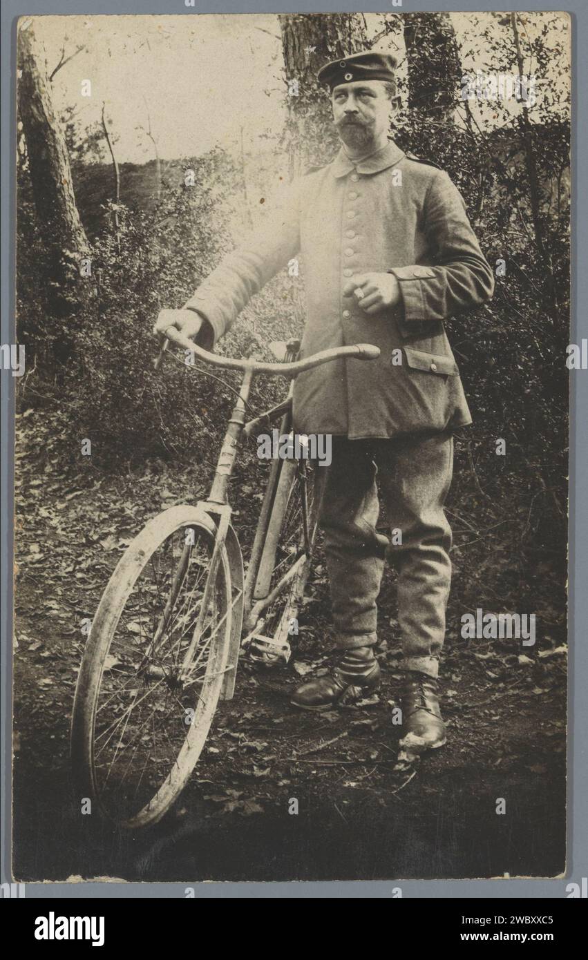 Portrait of an unknown man in uniform with a bicycle in hand, anonymous ...