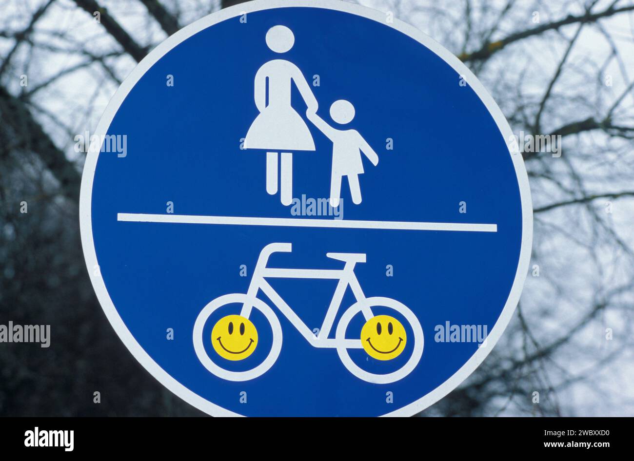 closeup of pedestrian and bike cycle path sign, one bicycle and a mother with child, with smiley ...