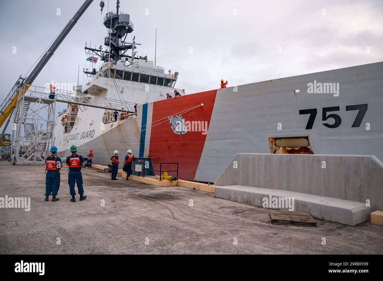Workers on the pier prepare the crossing brow after the mooring of the ...