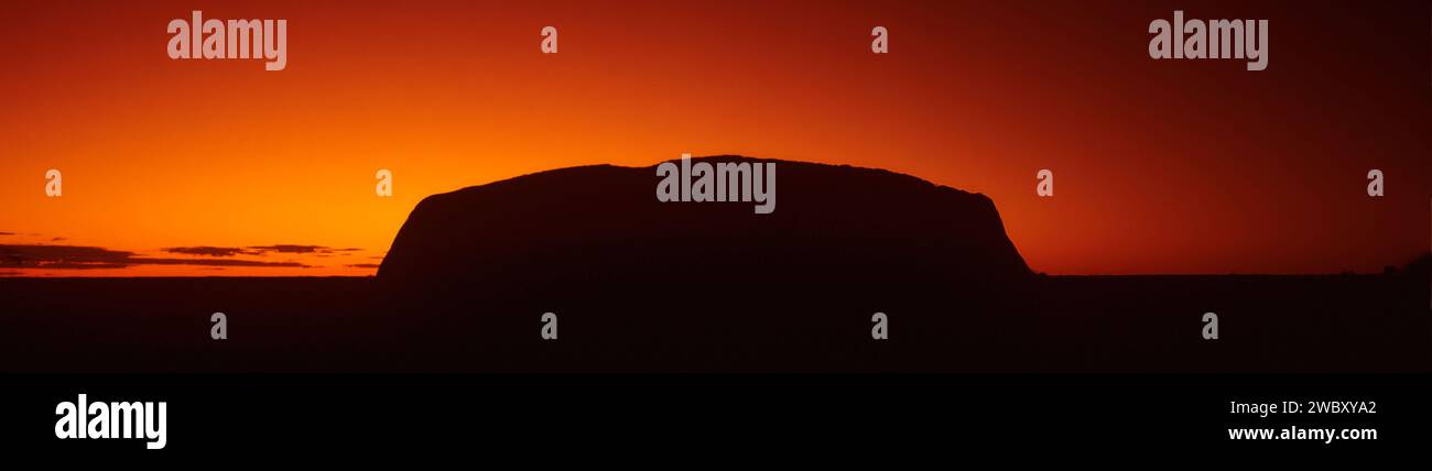Ayers Rock Uluru at sunset, red sky, black silhouette, Northern ...