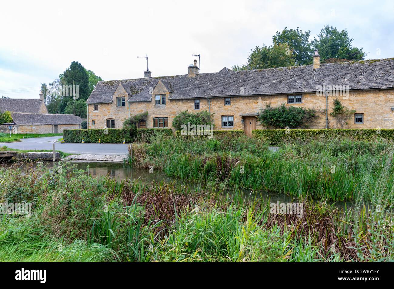 Lower Slaughter village Cotswolds England and rows of English honey ...