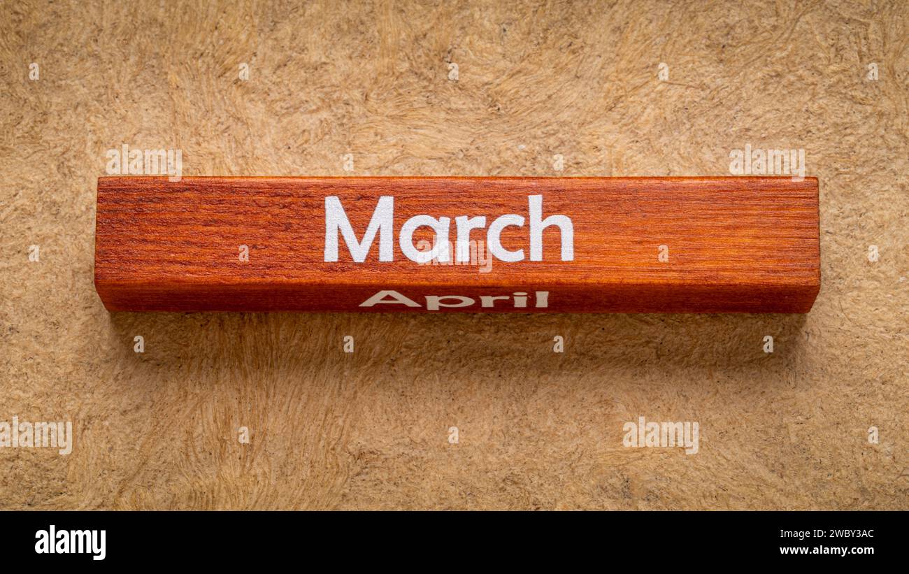 March and April text on wooden block against handmade bark paper in ...