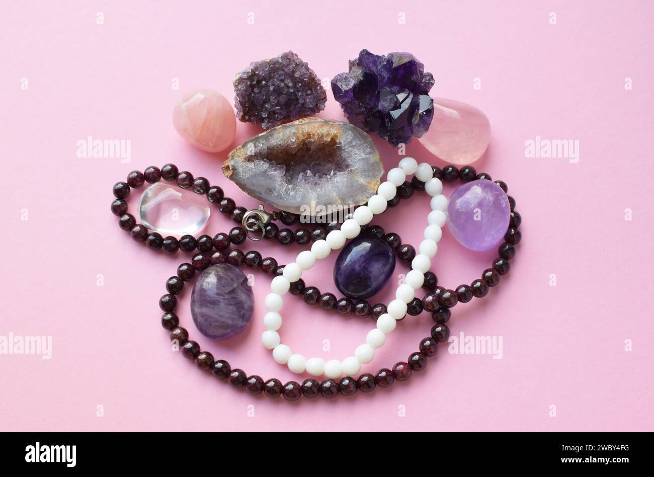 Garnet beads and amethyst, rose quartz and rock crystal crystals on a ...