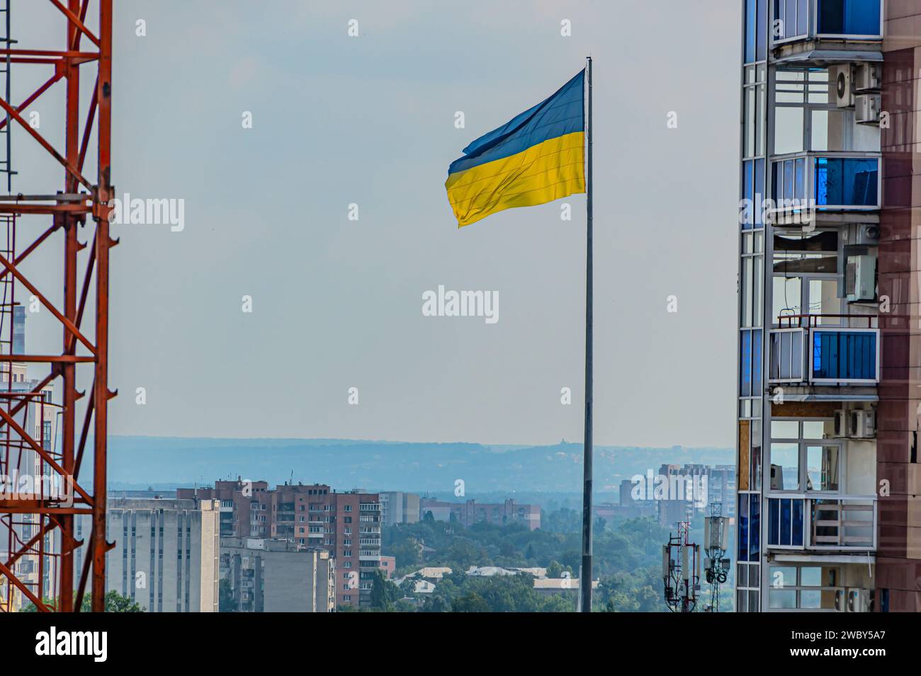 Ukrainian flag amidst urban development. Symbol of Ukraine's ...