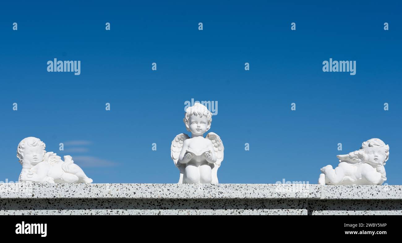 three angels statues, background with copy spcae Stock Photo - Alamy
