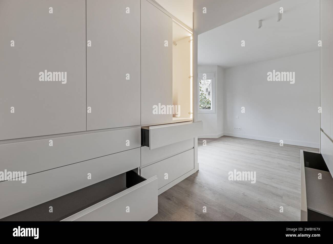 Large dressing room in an empty room with built-in wardrobes on both ...