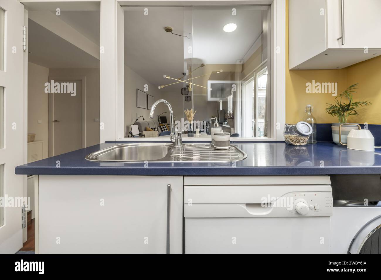 Kitchen with stainless steel sink, serving hatch and blue countertop ...