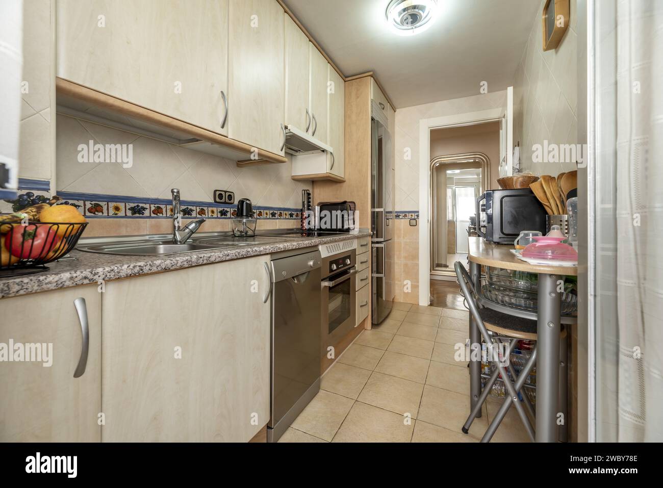 Conventional kitchen front with integrated appliances, stoneware floors ...