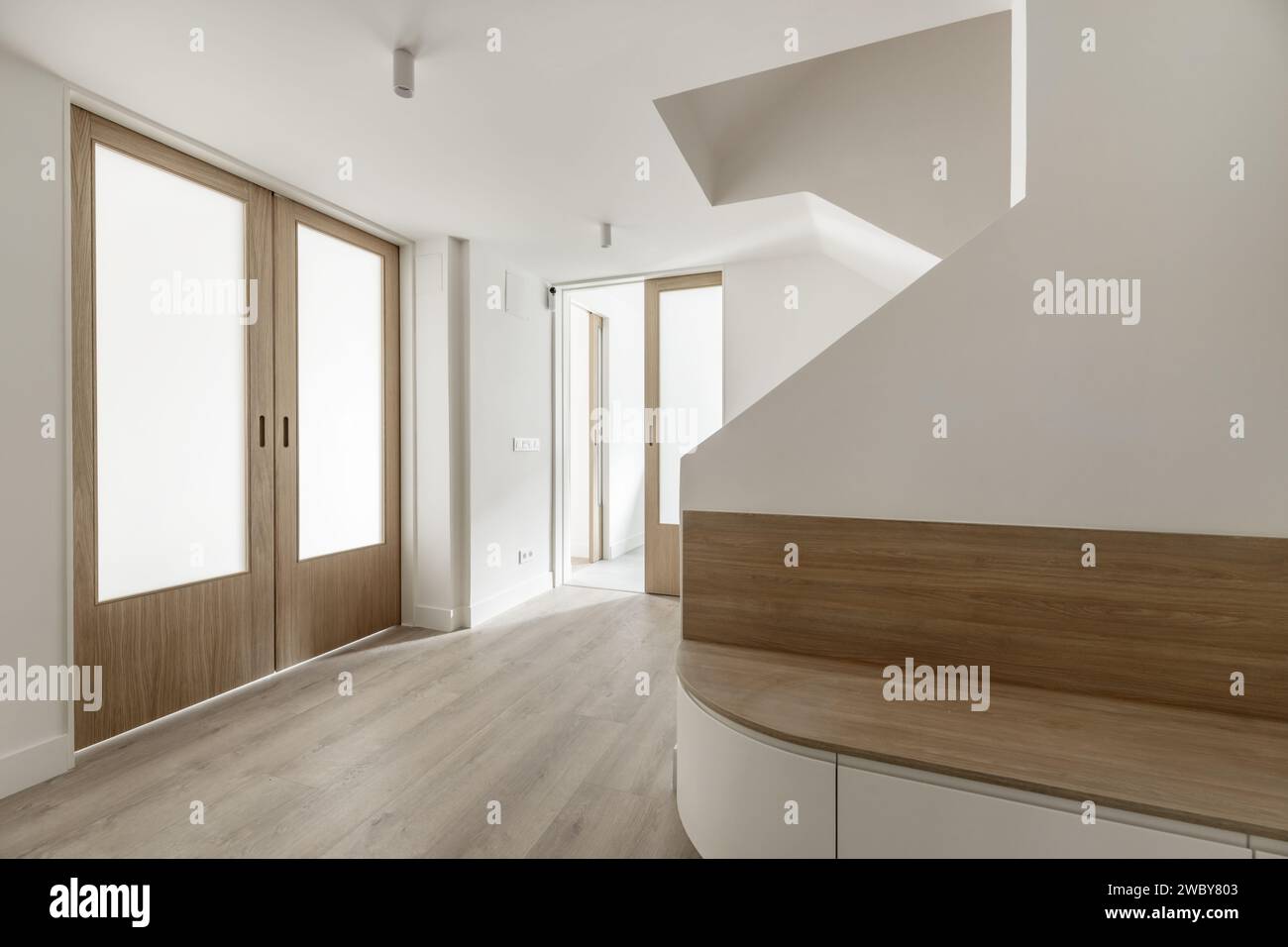 Hall area of a house with smooth white painted walls, sliding wooden ...