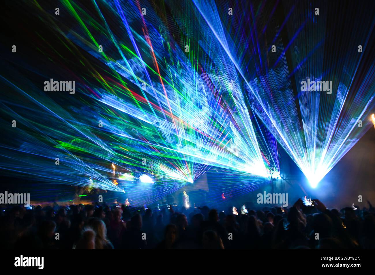 Multicolored light show at night. Laser lights and fog on the stage ...