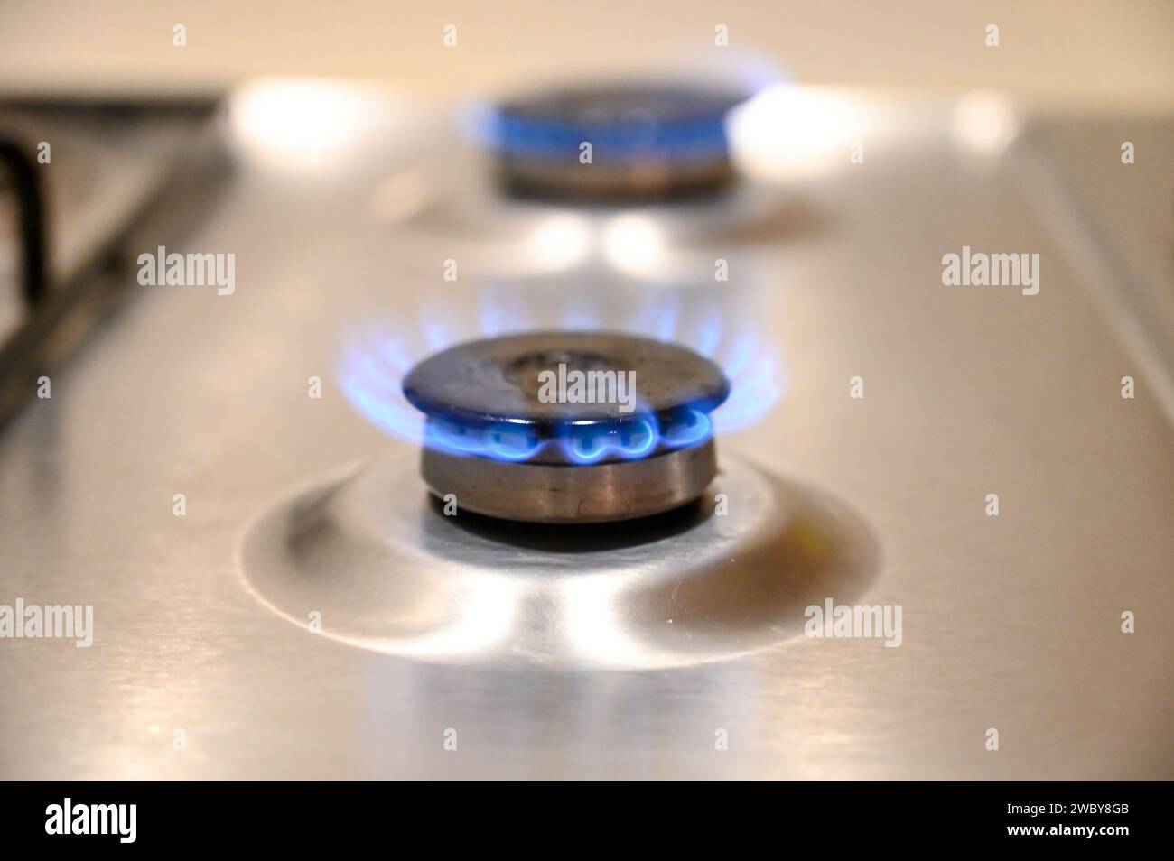 Gas cooker in kitchen. Close up of blue flames on gas stove burner in ...