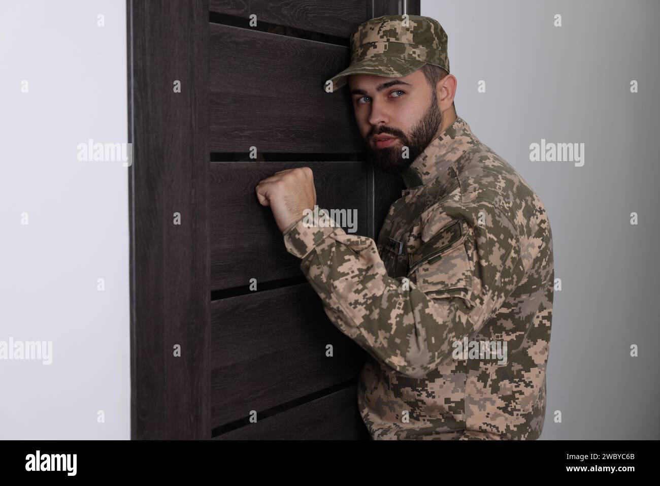 Military commissariat representative knocking on wooden door Stock ...