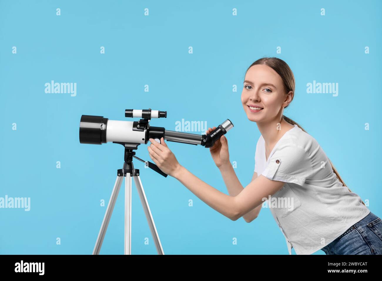Happy astronomer with telescope on light blue background Stock Photo ...