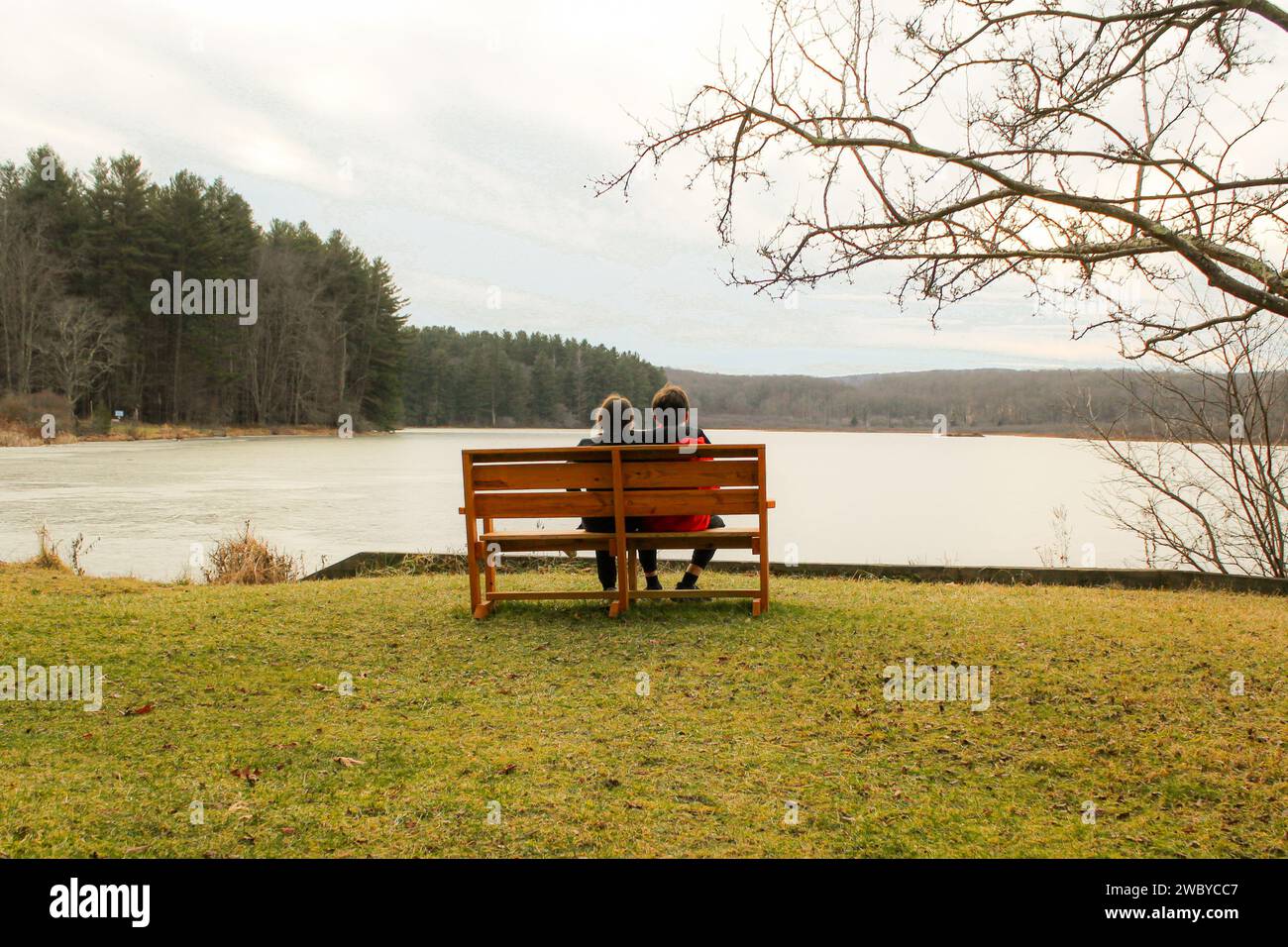 Two friends on a bench beside a lake Stock Photo - Alamy