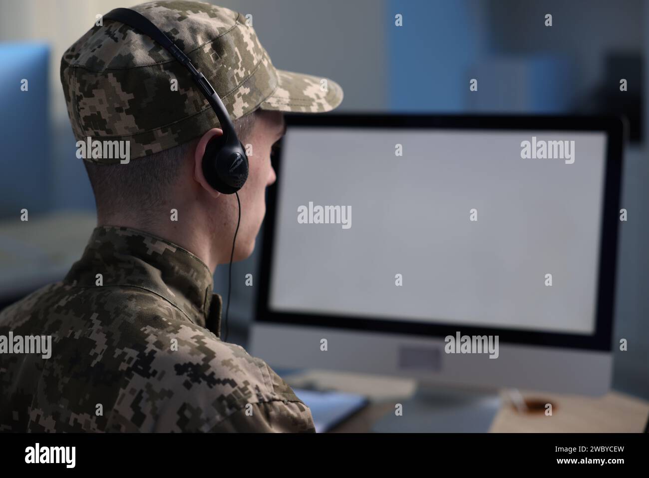 Military service. Soldier in headphones working in office, space for ...