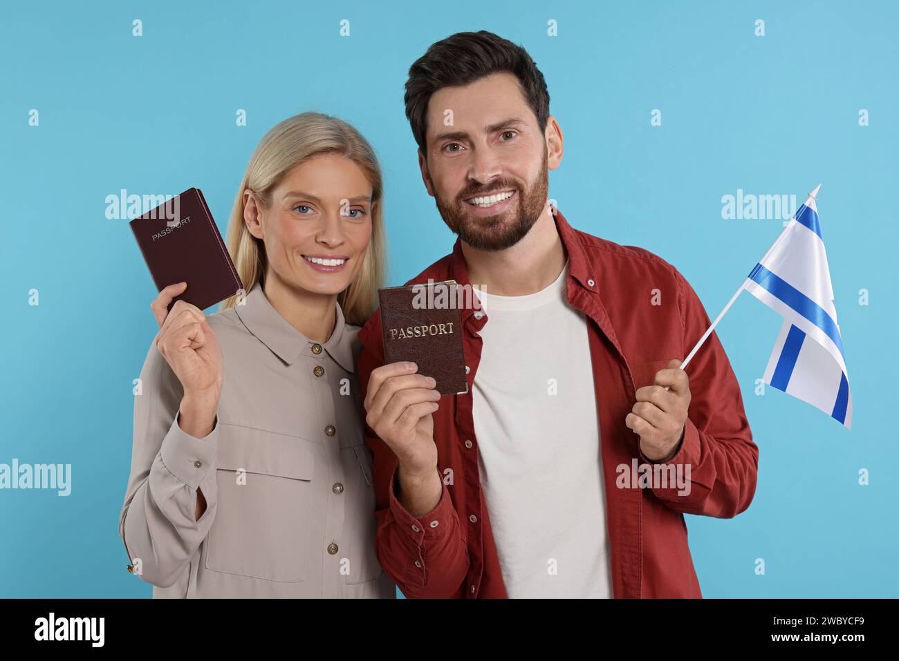 Immigration. Happy couple with passports and flag of Israel on light ...