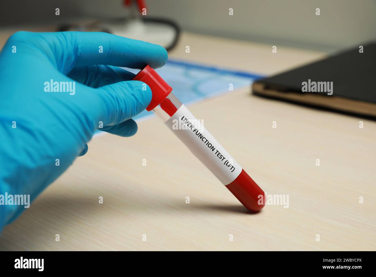 Laboratory worker holding tube with blood sample and label Liver ...