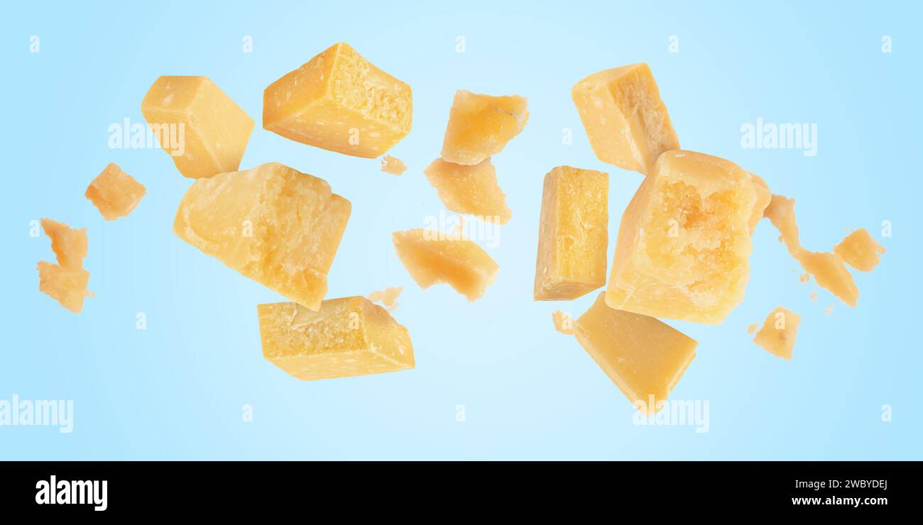 Tasty parmesan cheese falling on light blue background. Banner design ...