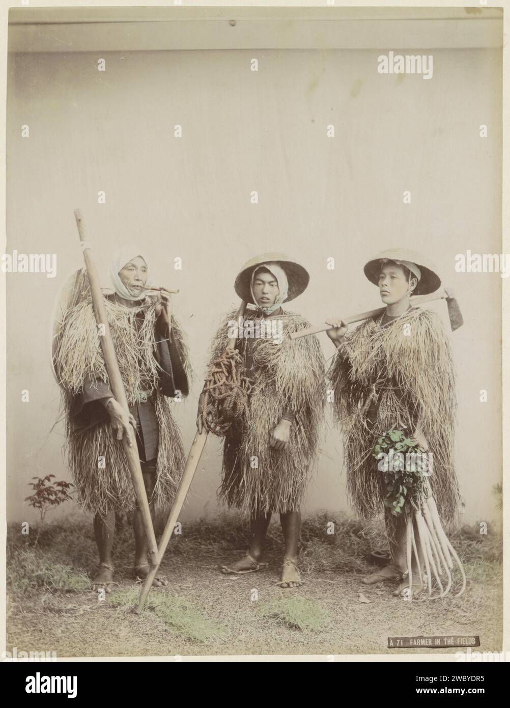 Portrait of three Japanese farmers with thatched clothing and tools ...