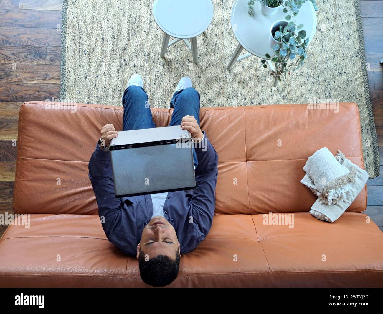 40-year-old dark-skinned Latin man does home office in the living room ...