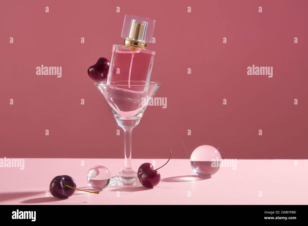 A glass perfume bottle placed inside a cocktail glass decorated with ...