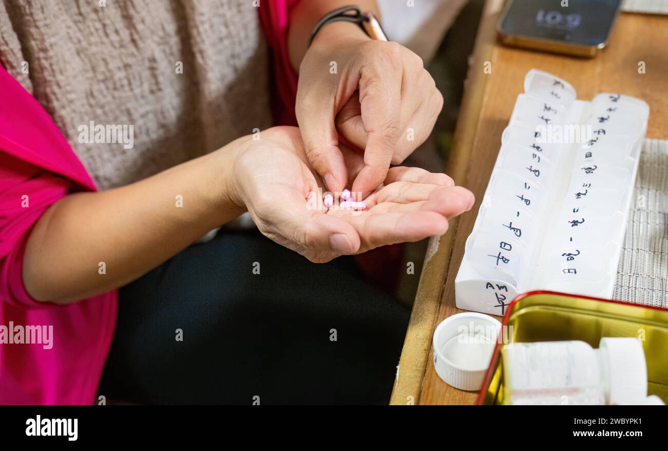 Female hands sorting pills into medical pill boxes. Pill box with ...