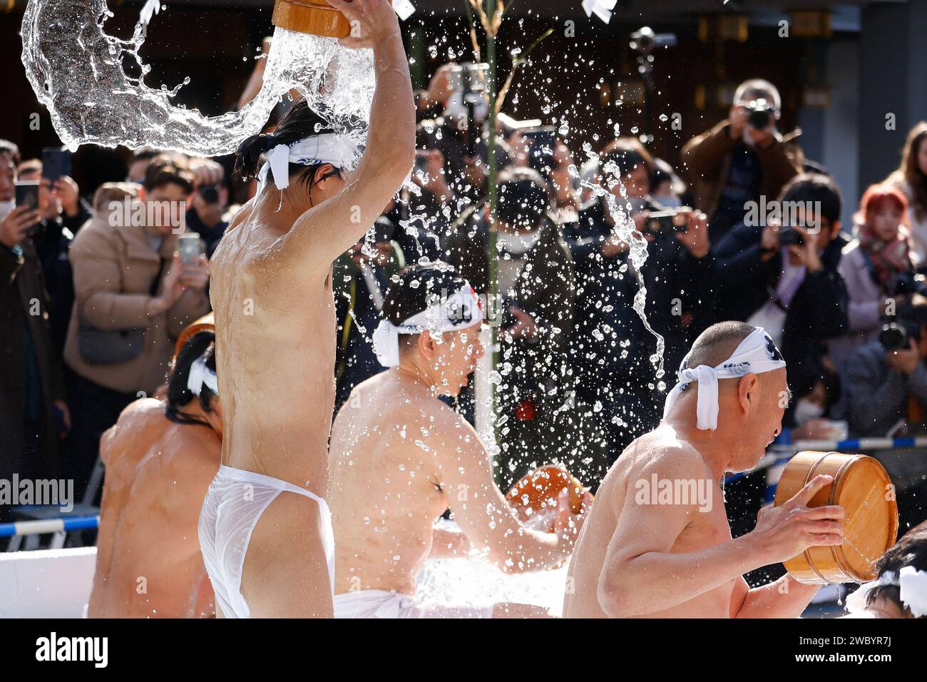 Tokyo, Japan. 13th Jan, 2024. Participants dressed only in loincloth pour cold water over ...