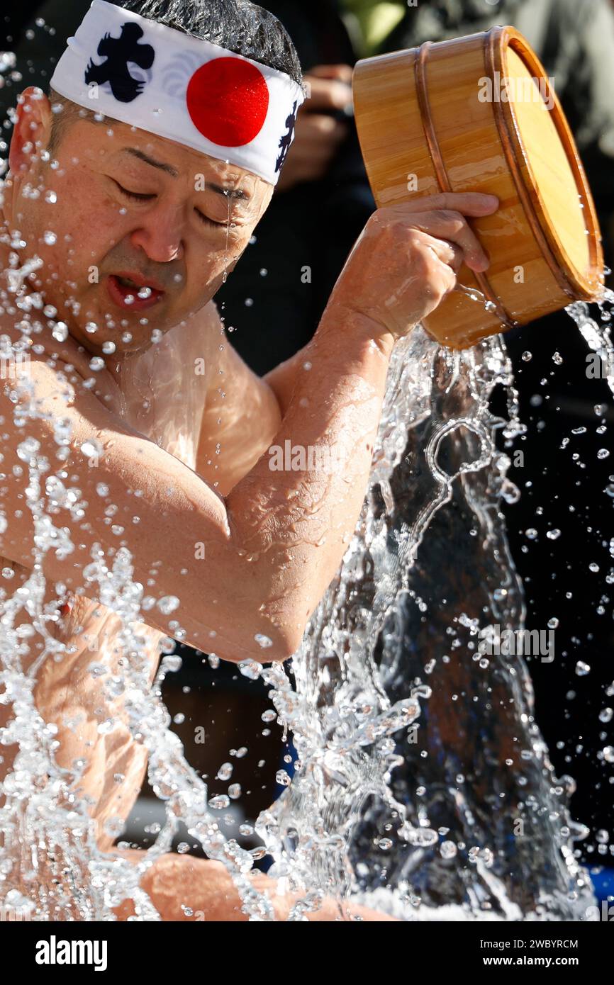 Tokyo, Japan. 13th Jan, 2024. A man dressed only in loincloth pours ...