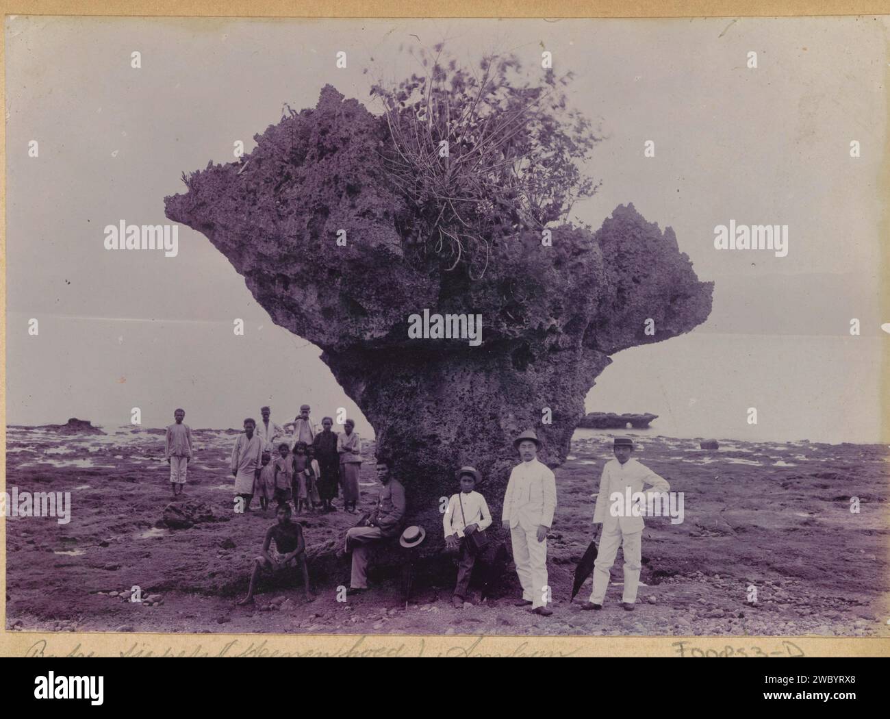 Group of people at rock formation Stenen Hoed (Batoe Tjepeh) on Ambon ...