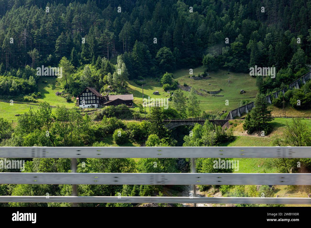 A brown Swiss country home on a green hillside in Uri, Switzerland ...