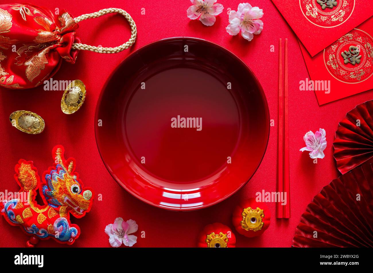 Red plate with chopstick on red cloth background with ingots(word mean ...