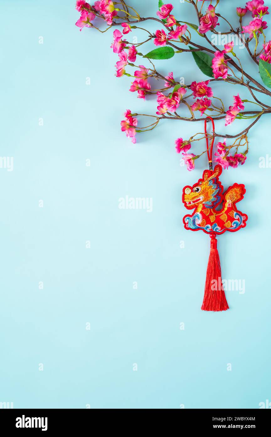 A dragon pendant hanging at pink chinese blossom tree on blue ...