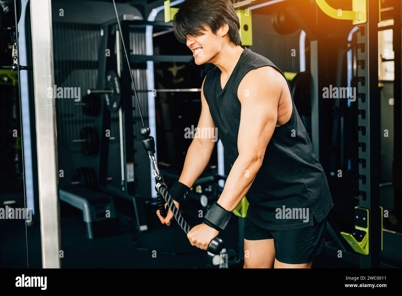 Young man performing cable triceps pulldowns to build muscle and ...