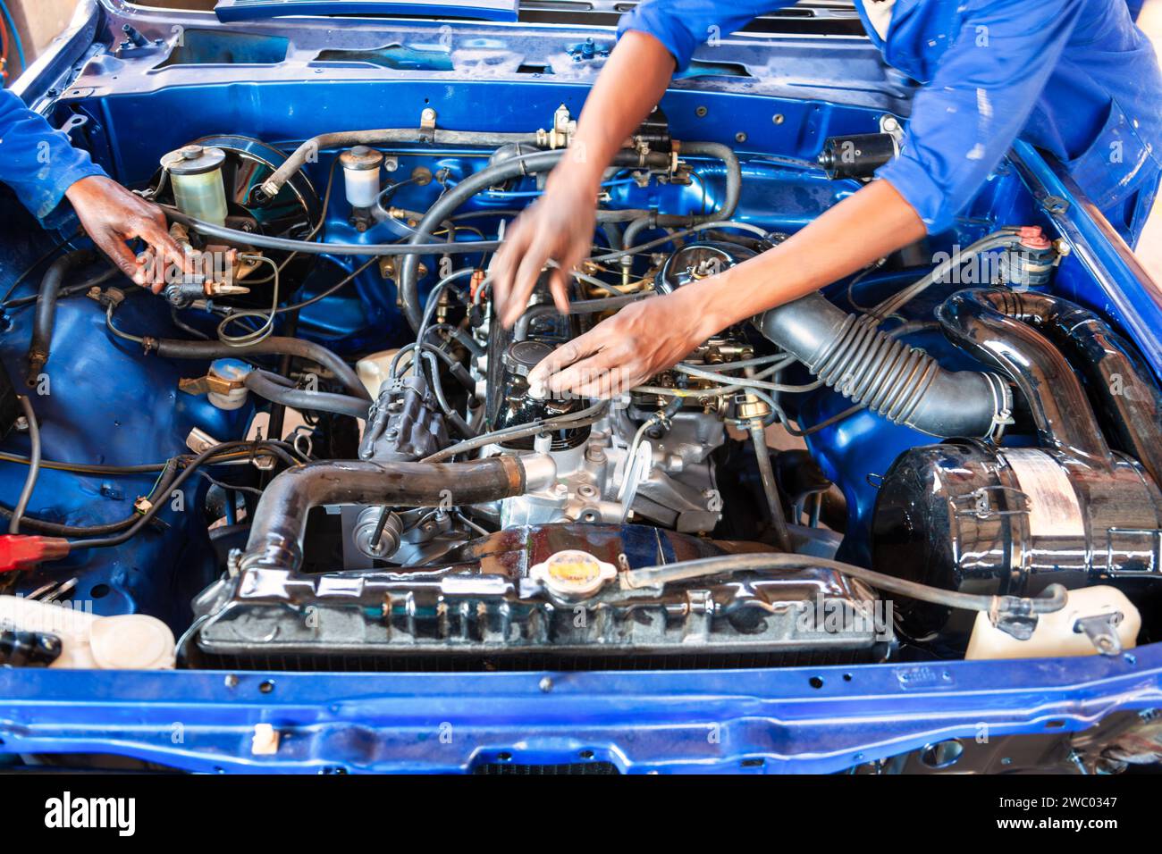 african american mechanic repairing engine motor view under the hood ...