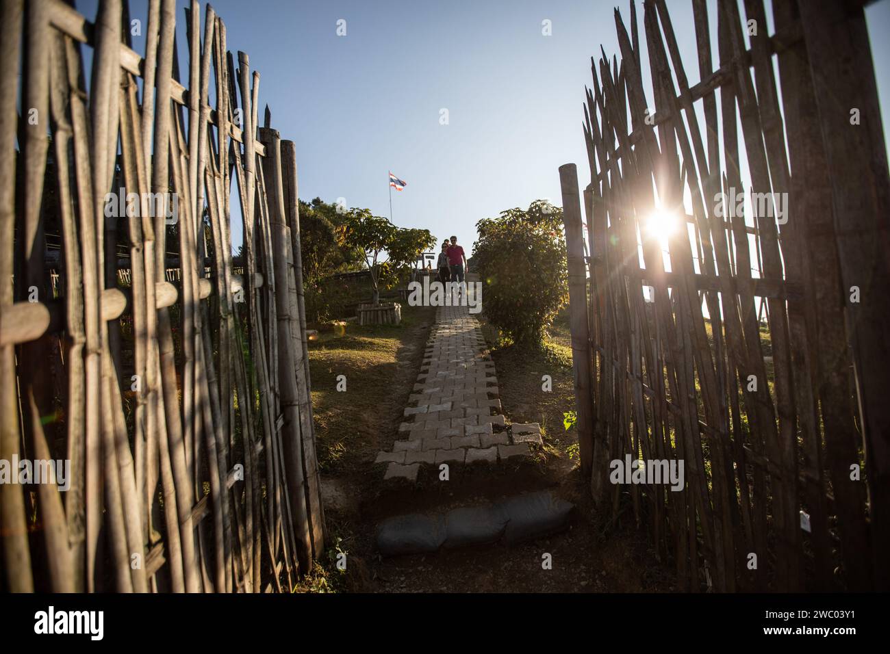 Narrow pathway surrounded by high bamboo fences to enter the Chang Moob ...