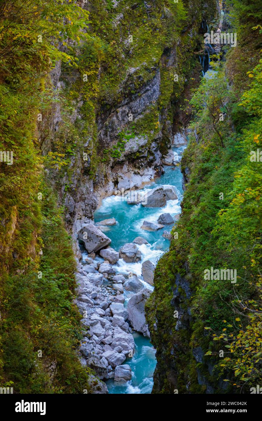 A mountain gorge with a fast flowing river, surrounded by high cliffs ...