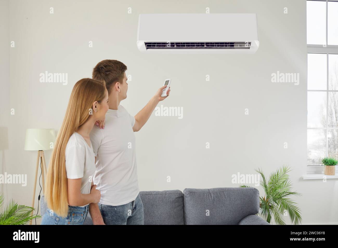 Couple Activating Wall Mounted Air Conditioner at Home Stock Photo - Alamy