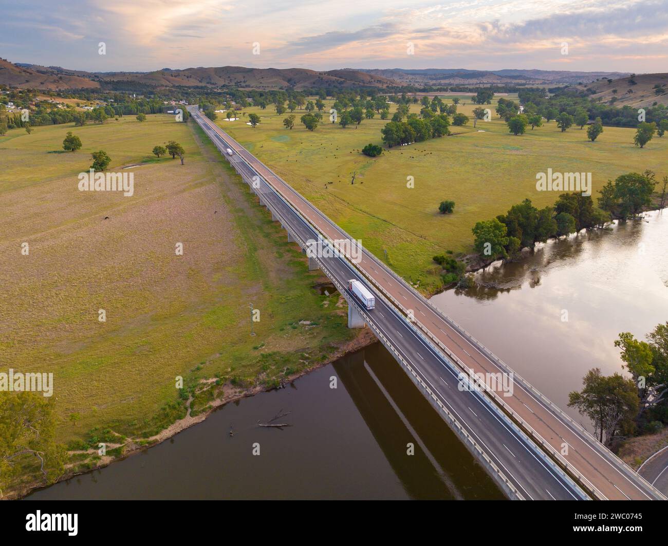 Aerial view of traffic on a highway bridge over a river flowing through ...