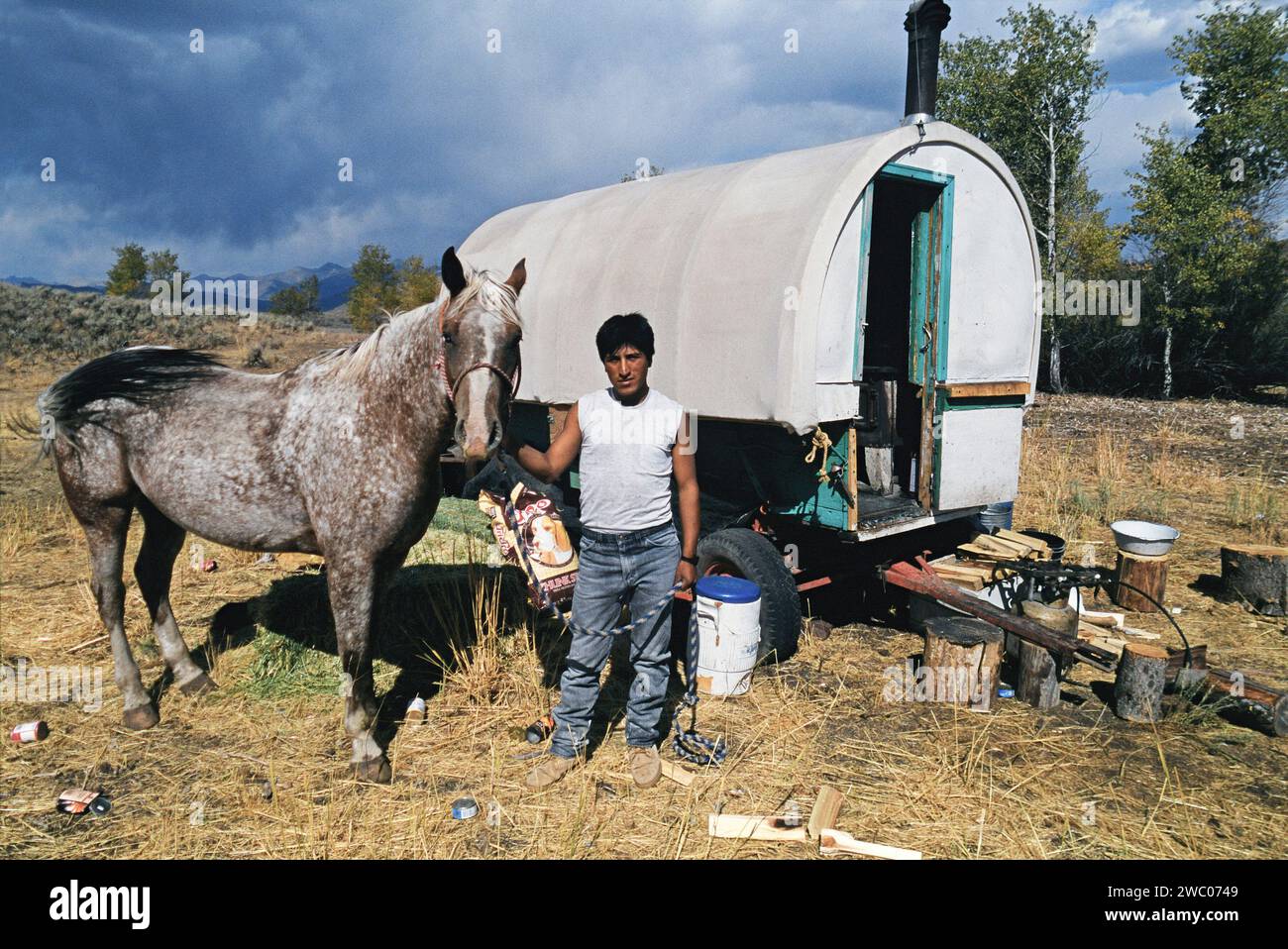Peruvian shepherd with his horse standing outside his sheep wagon in ...