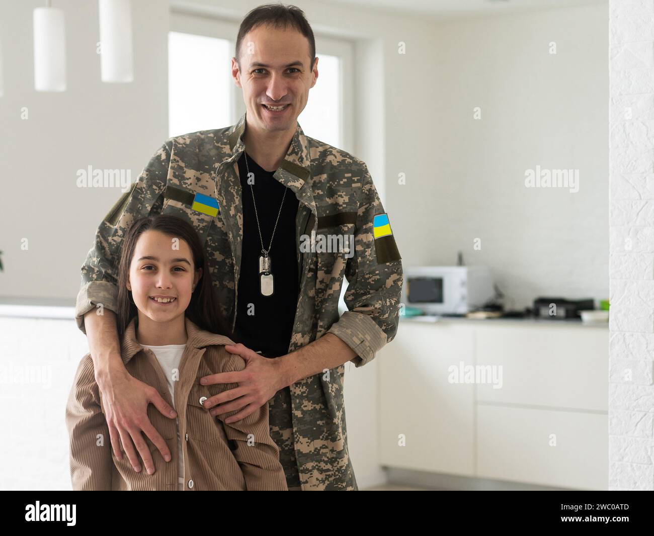 Father in Ukrainian military uniform and his daughter. Family reunion ...