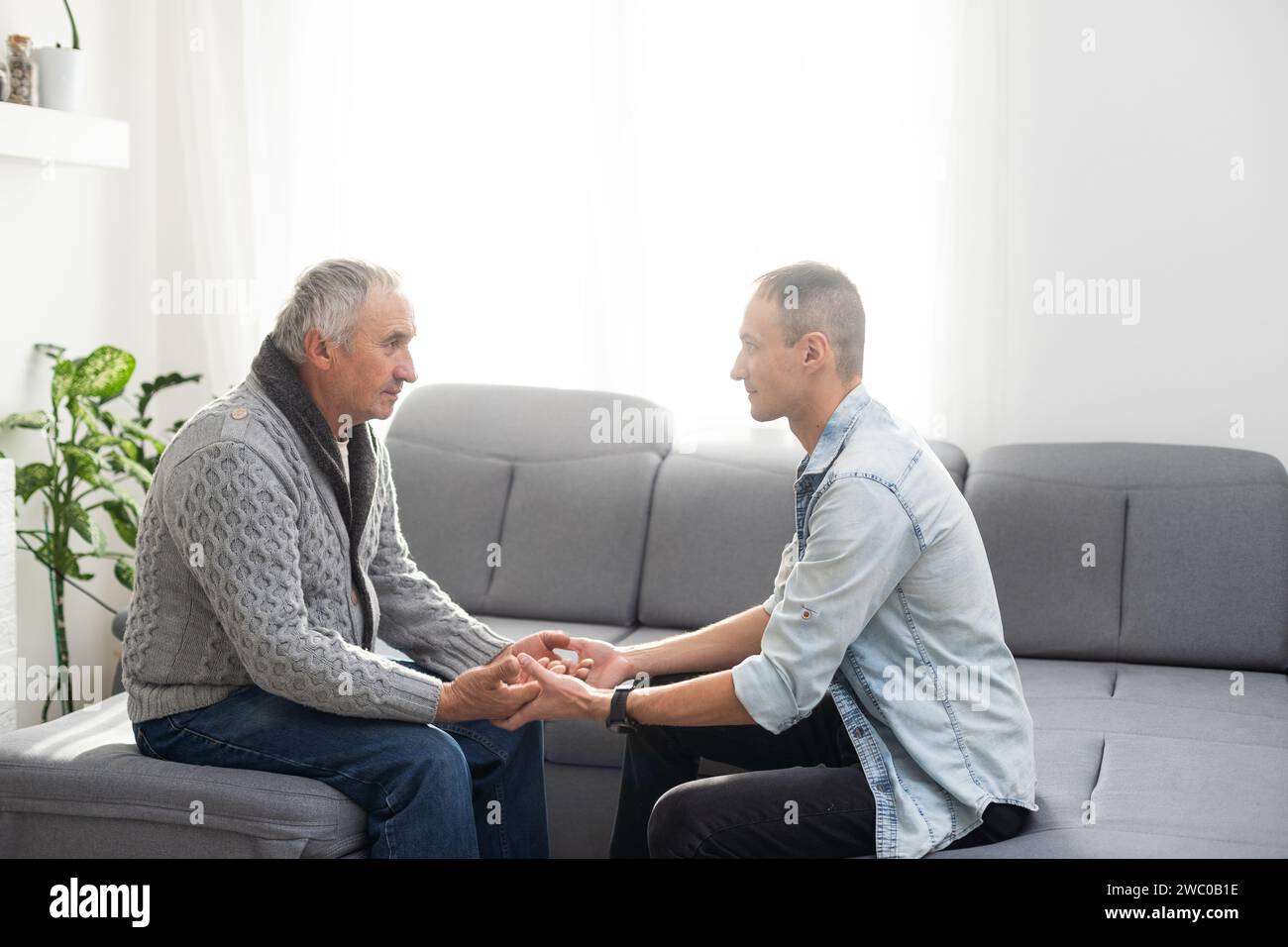 Elderly son takes care of ill father Stock Photo - Alamy