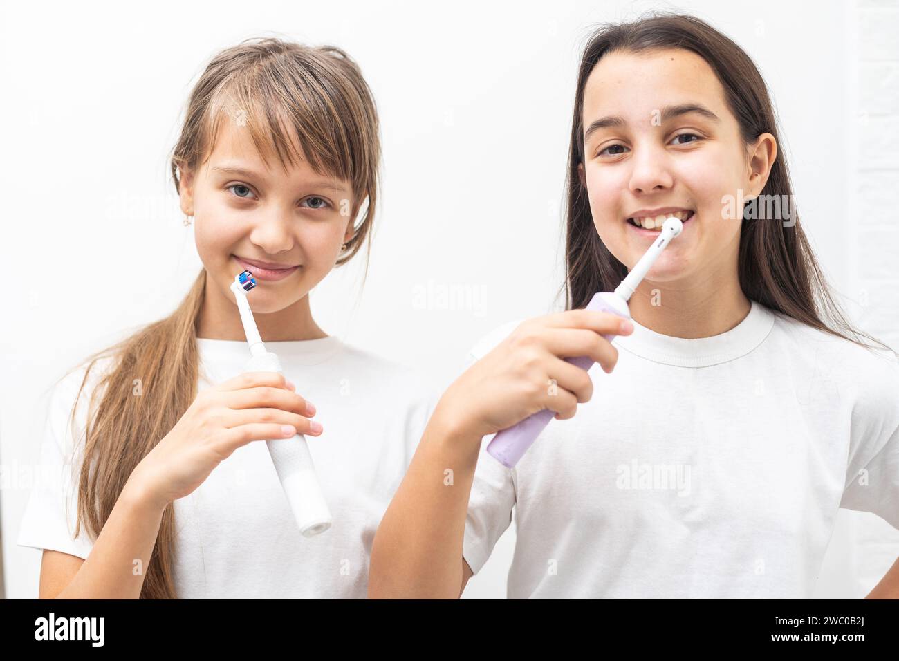 Portrait of two beautiful girls kids with perfect smile holding ...