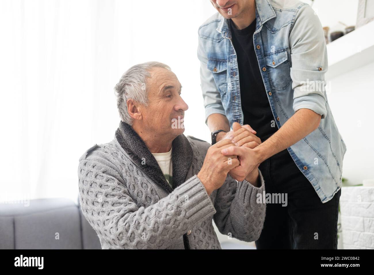 Elderly son takes care of ill father Stock Photo - Alamy