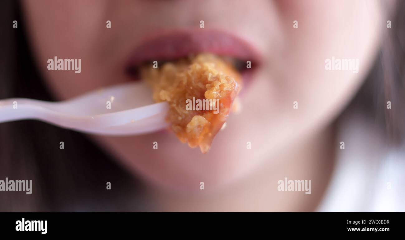 Woman eating fried chicken blurred background, Street food in thailand ...