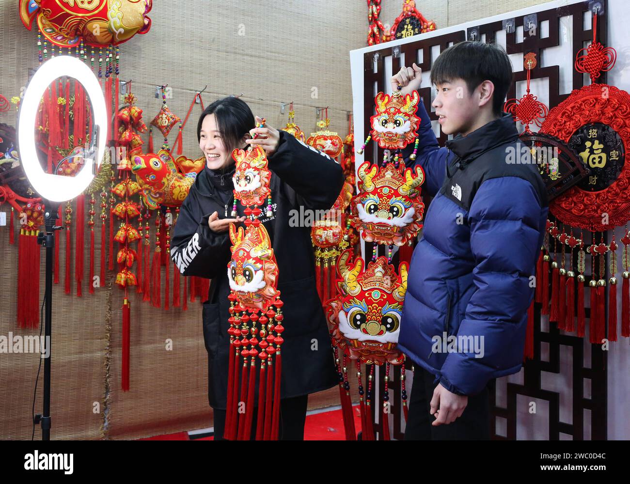 Linyi, China. 13th Jan, 2024. A staff member is selling ''Chinese knots'' through an online ...