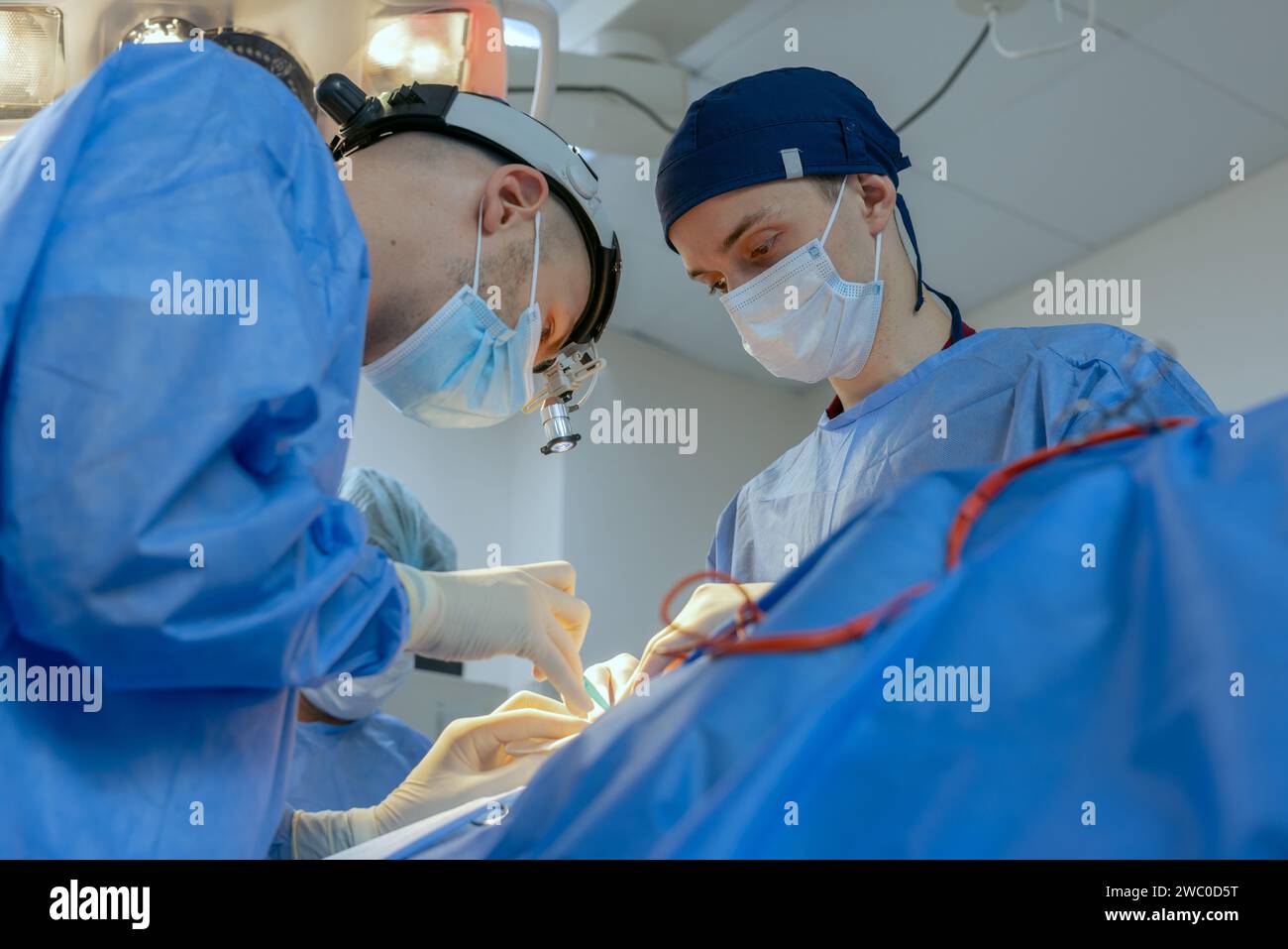 male surgeons perform surgery in operating room, plastic surgeon in ...