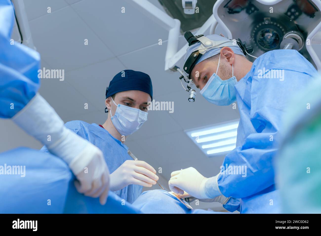 male surgeons perform surgery in operating room, plastic surgeon in ...