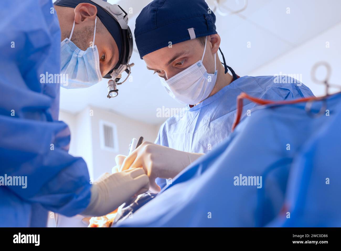 male surgeons perform surgery in operating room, plastic surgeon in ...